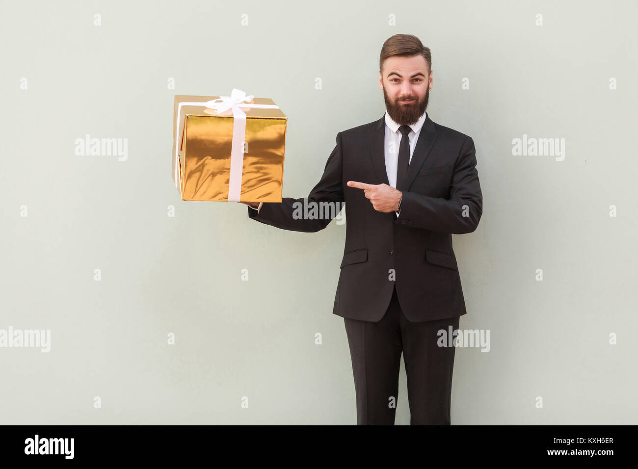 Handsome bearded businessman pointing finger gift box and happy looking ...