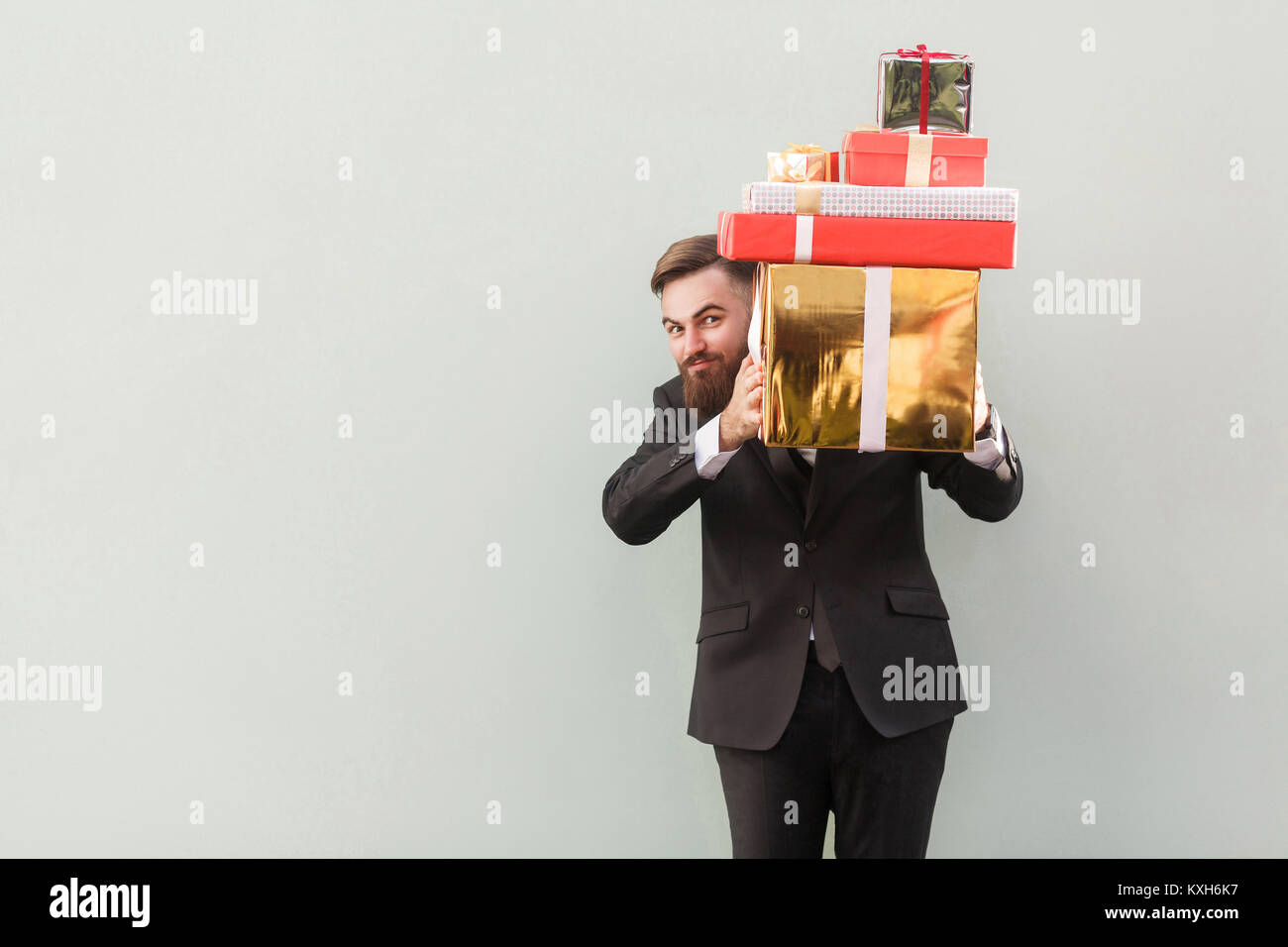 Funny man hiding behind boxes and looking at camera. Studio shot ...