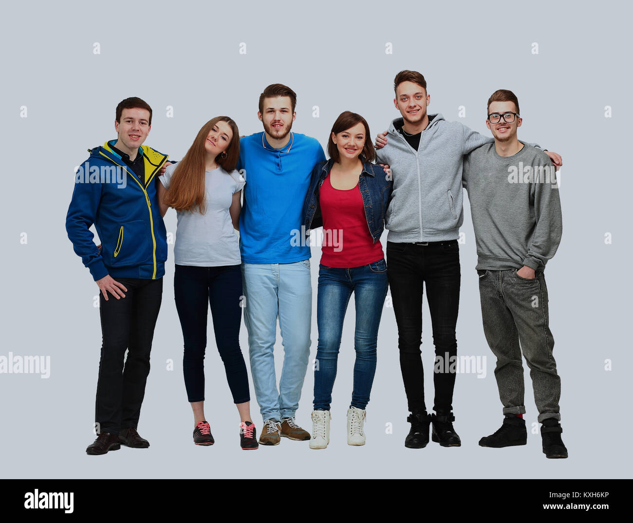 group of smiling friends staying together and looking at camera ...