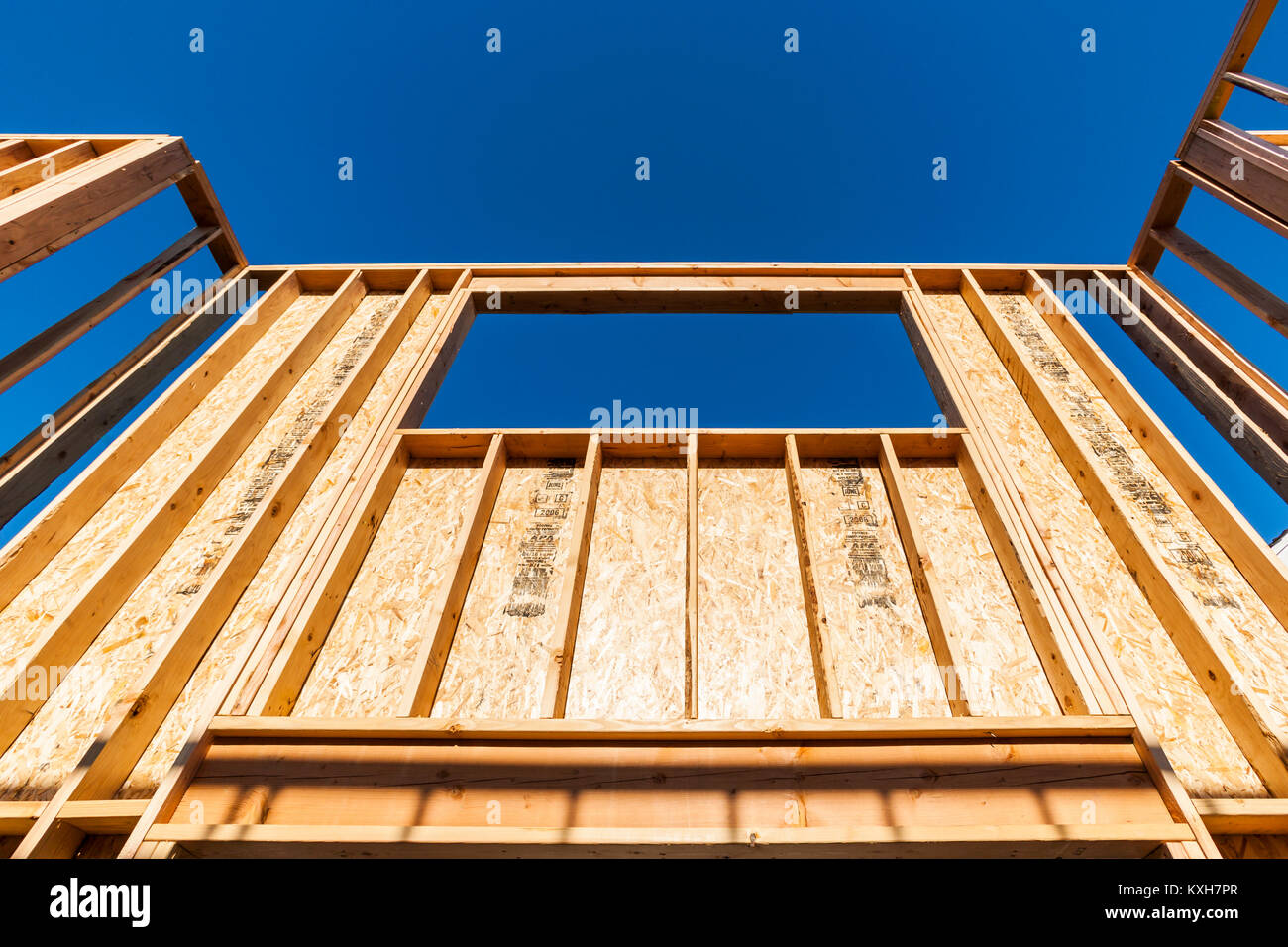 Looking up at a two story wall with a window in it from the bottom ...