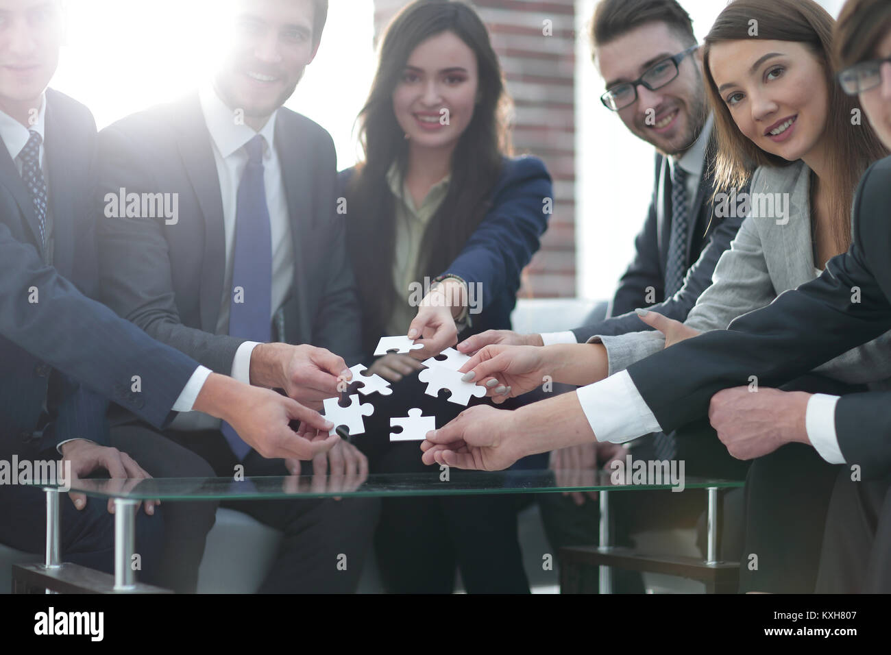 Business team solving puzzle together Stock Photo - Alamy