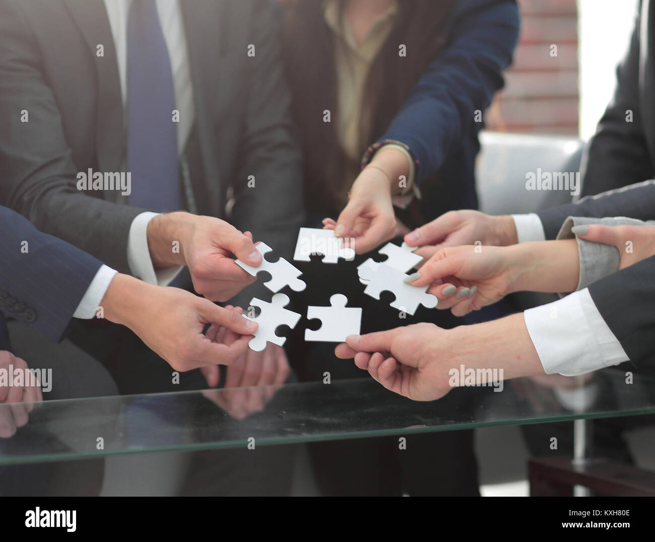 Business team solving puzzle together Stock Photo - Alamy