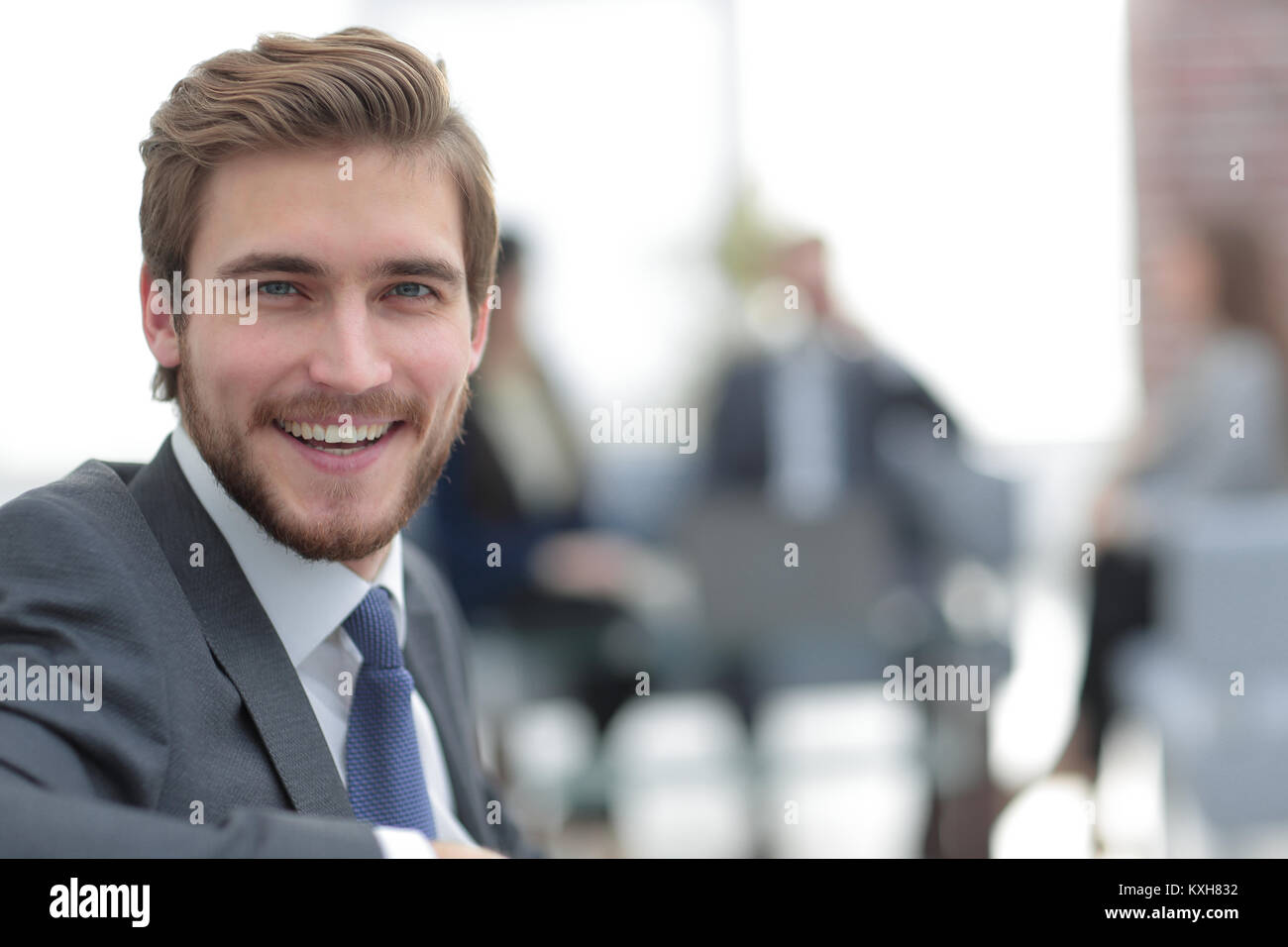 Successful business man standing with his staff in background at Stock ...