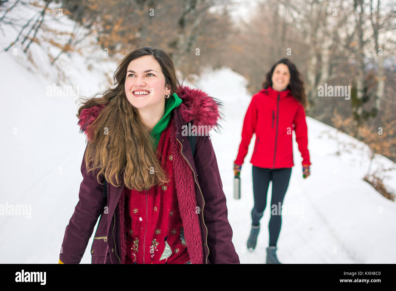 Two girls on a hiking trip on snowy mountain path Stock Photo - Alamy