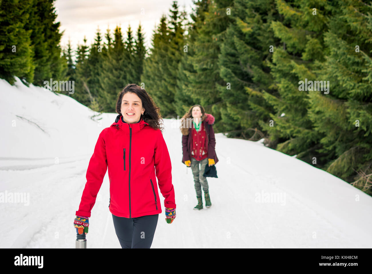 Happy girls on a hiking trip on snowy mountain path Stock Photo - Alamy