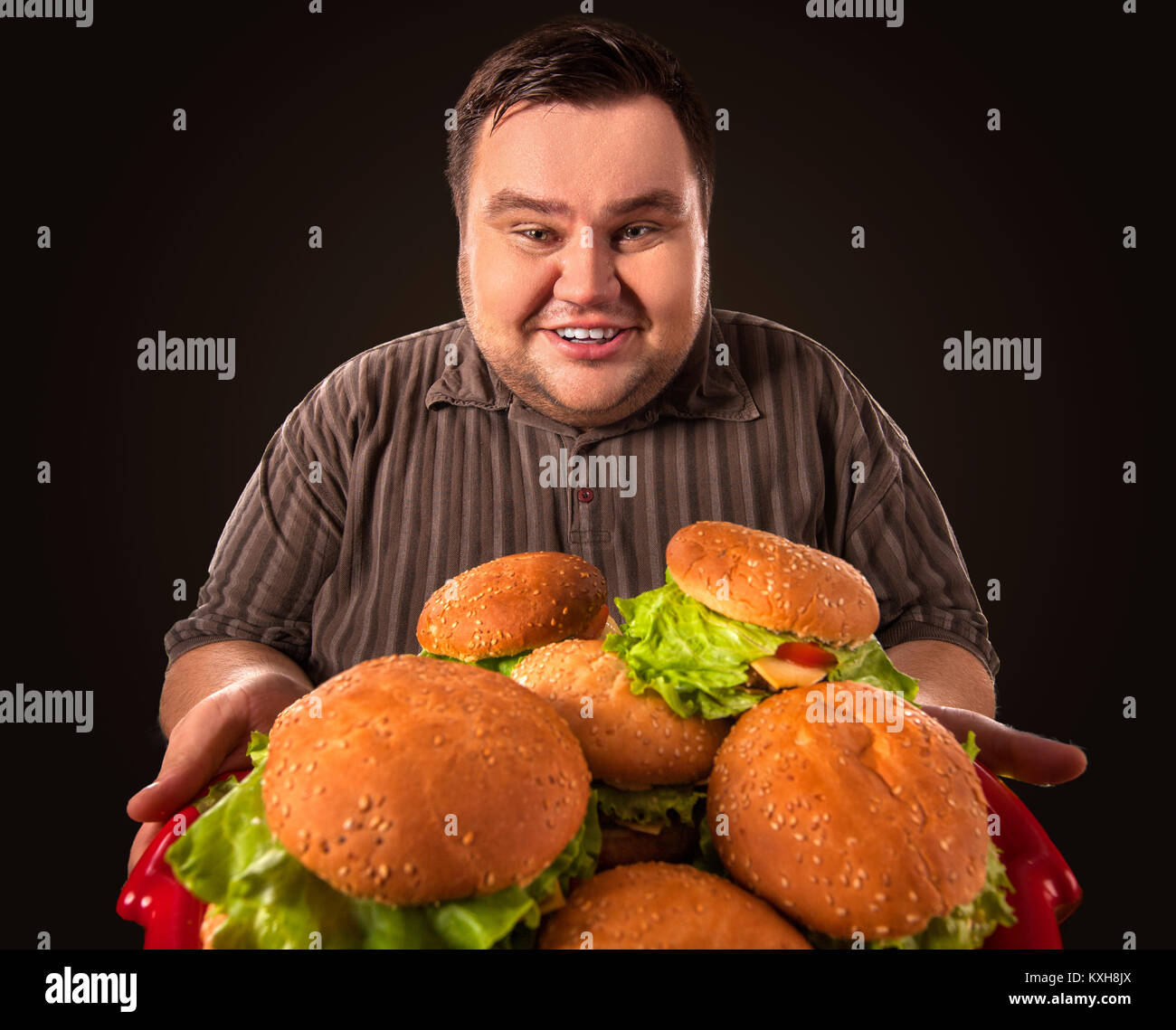 Fat man eating fast food hamberger. Breakfast for overweight person ...