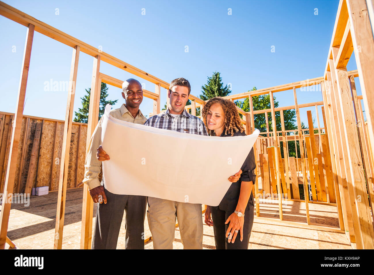 A couple reviews plans for a house with their contractor / architect on ...