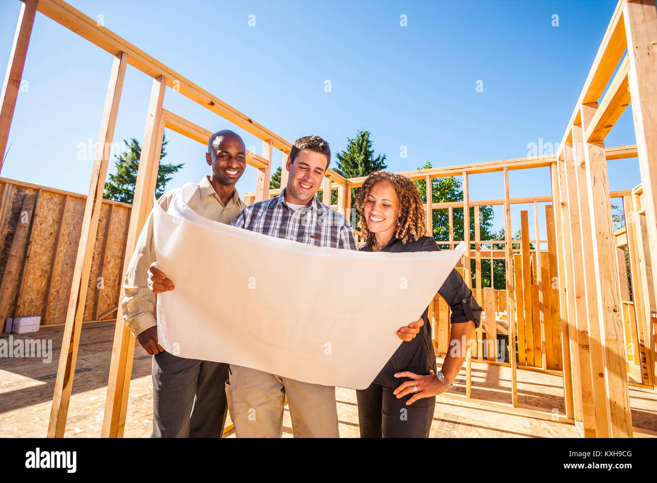 A couple reviews plans for a house with their contractor / architect on ...
