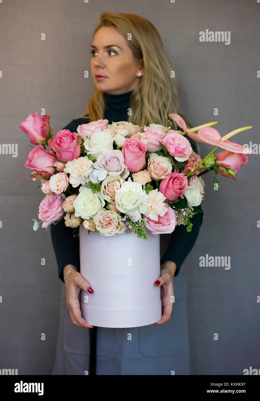 The beautiful bouquet of different roses in white box in female hands ...