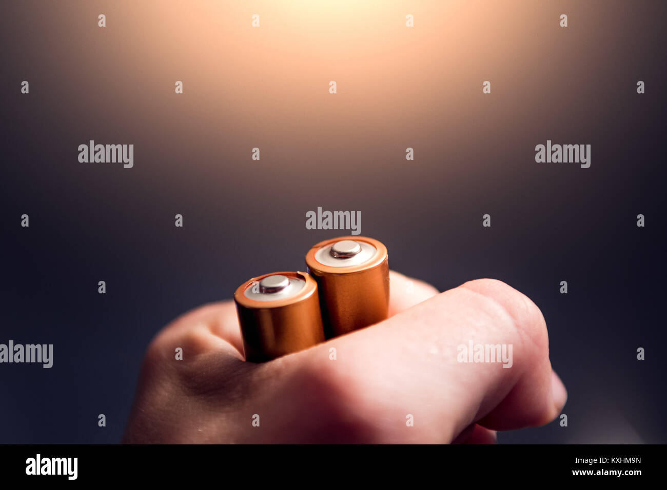 Cropped Hand holding two batteries Stock Photo - Alamy