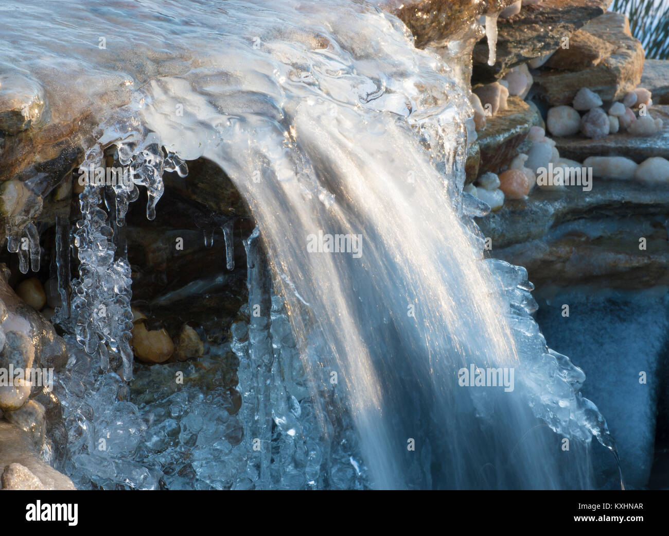 Small waterfall covered in ice with water flowing underneath Stock ...