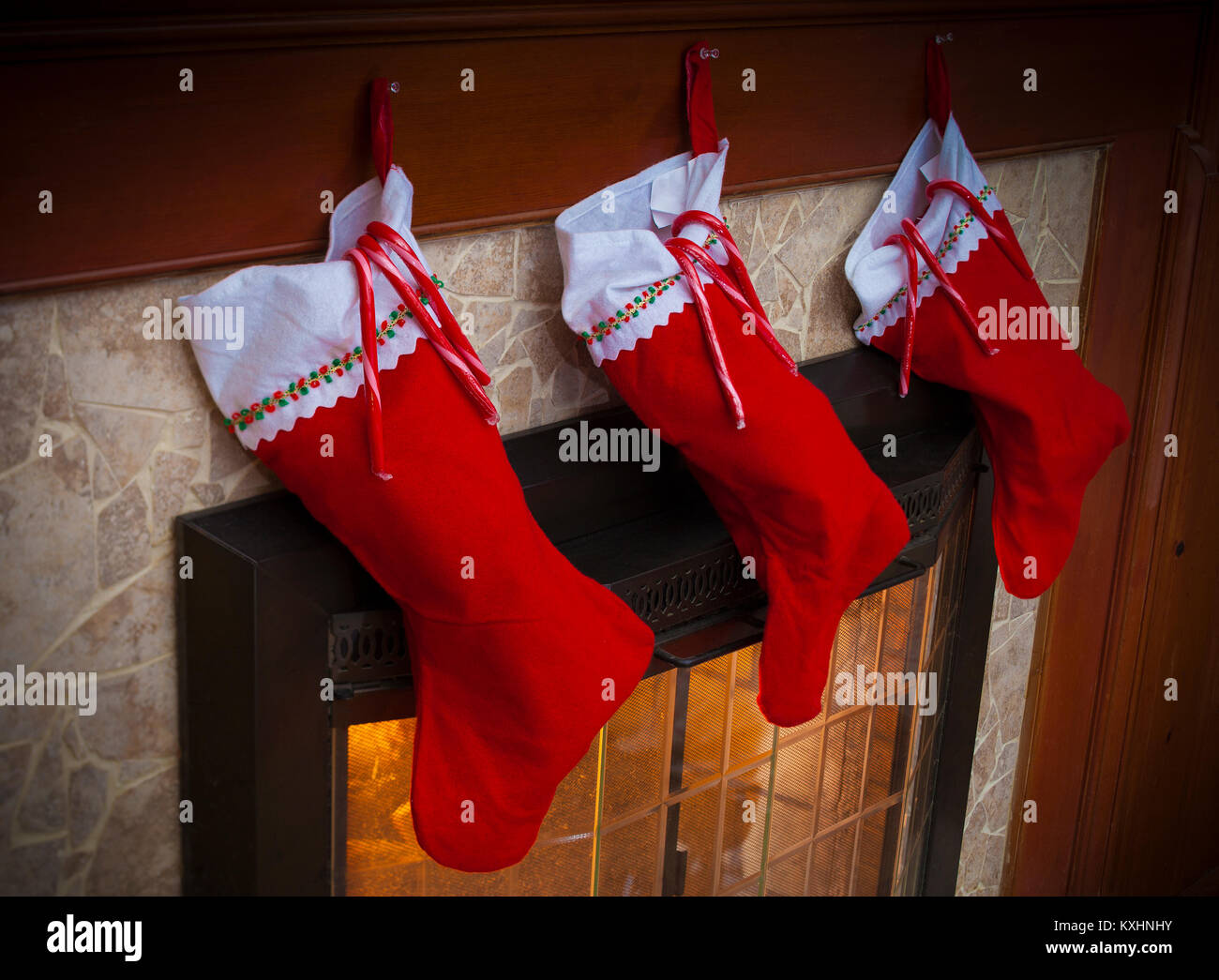 Three red Christmas stockings on the fireplace with candy canes Stock ...