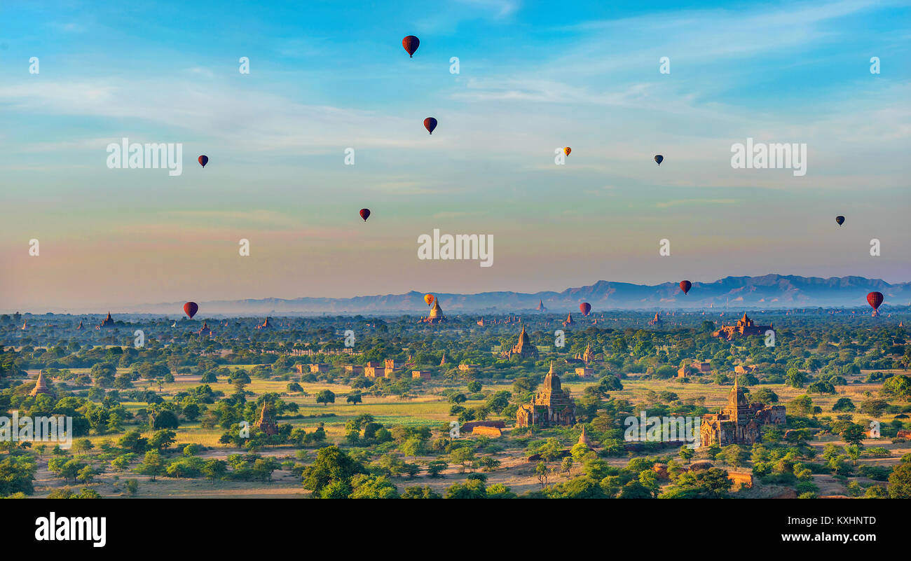 Hot air balloons flying in sky over beautiful pagodas at sunrise ...