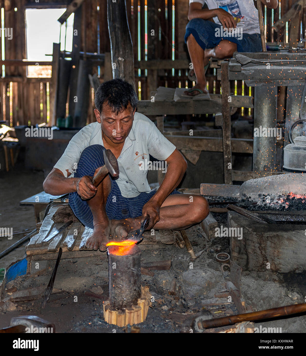Black smith beating iron rod using hammer, Inle, Myanmar Stock Photo ...