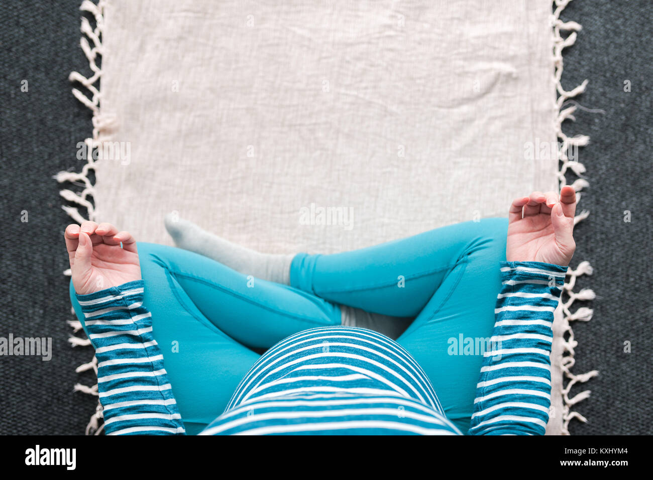 Overhead view of pregnant woman practicing yoga exercise at home ...
