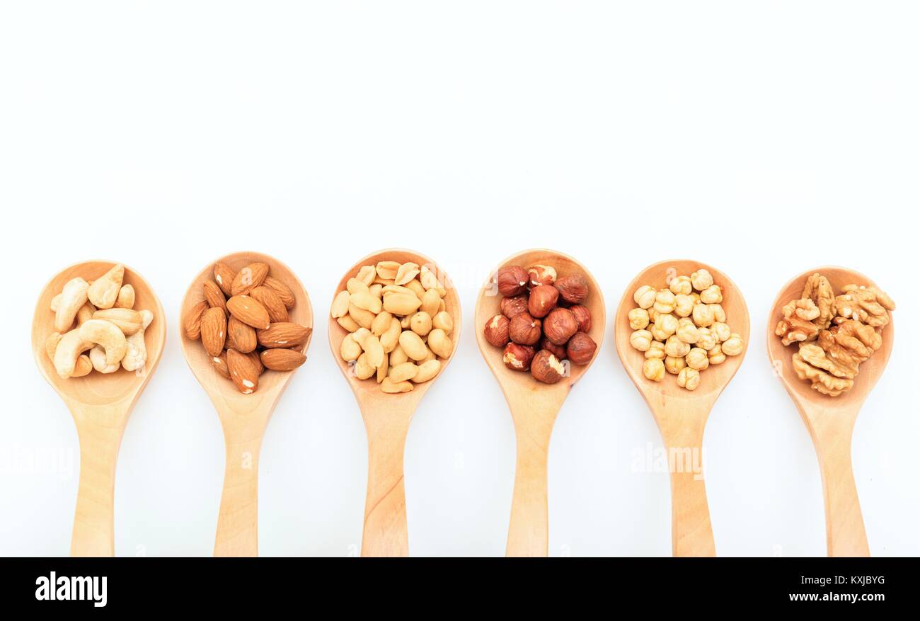 Various nuts in wooden spoons on white background Stock Photo - Alamy