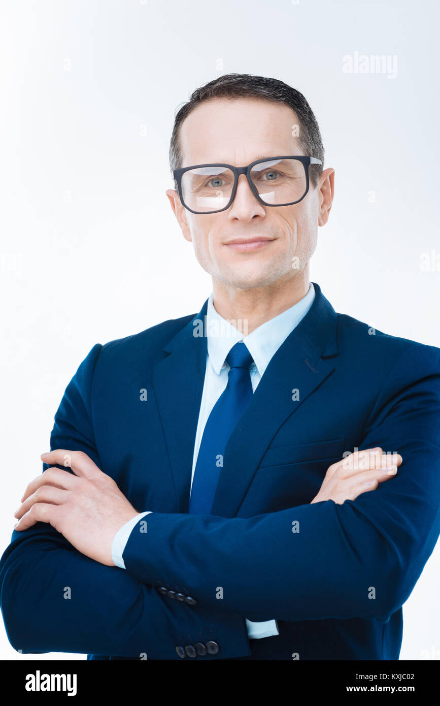 Confident intelligent man standing cross handed Stock Photo - Alamy