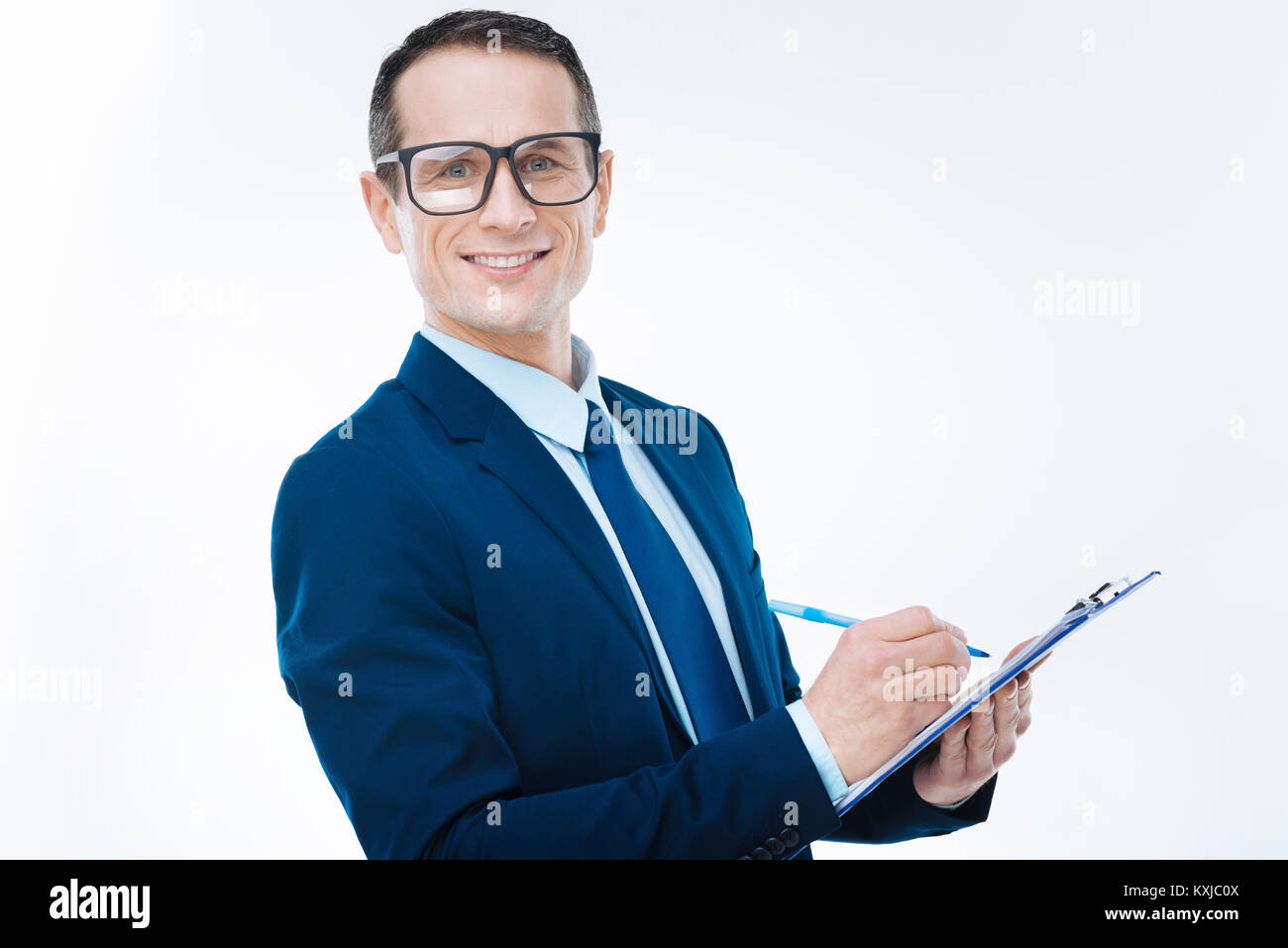 Happy pleasant man writing notes Stock Photo - Alamy