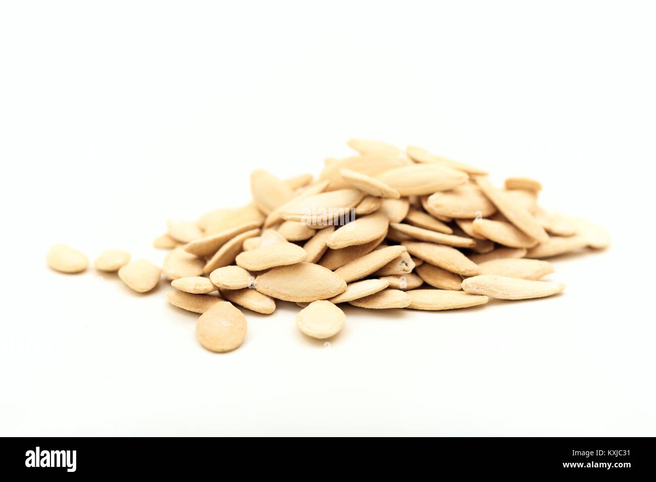 Unpeeled pumpkin seeds on white background Stock Photo - Alamy