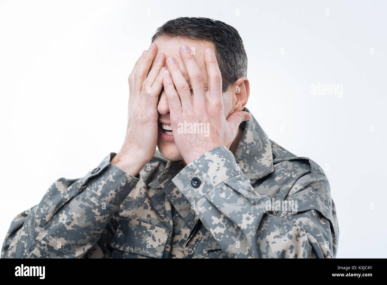 Handsome military man covering his face Stock Photo - Alamy