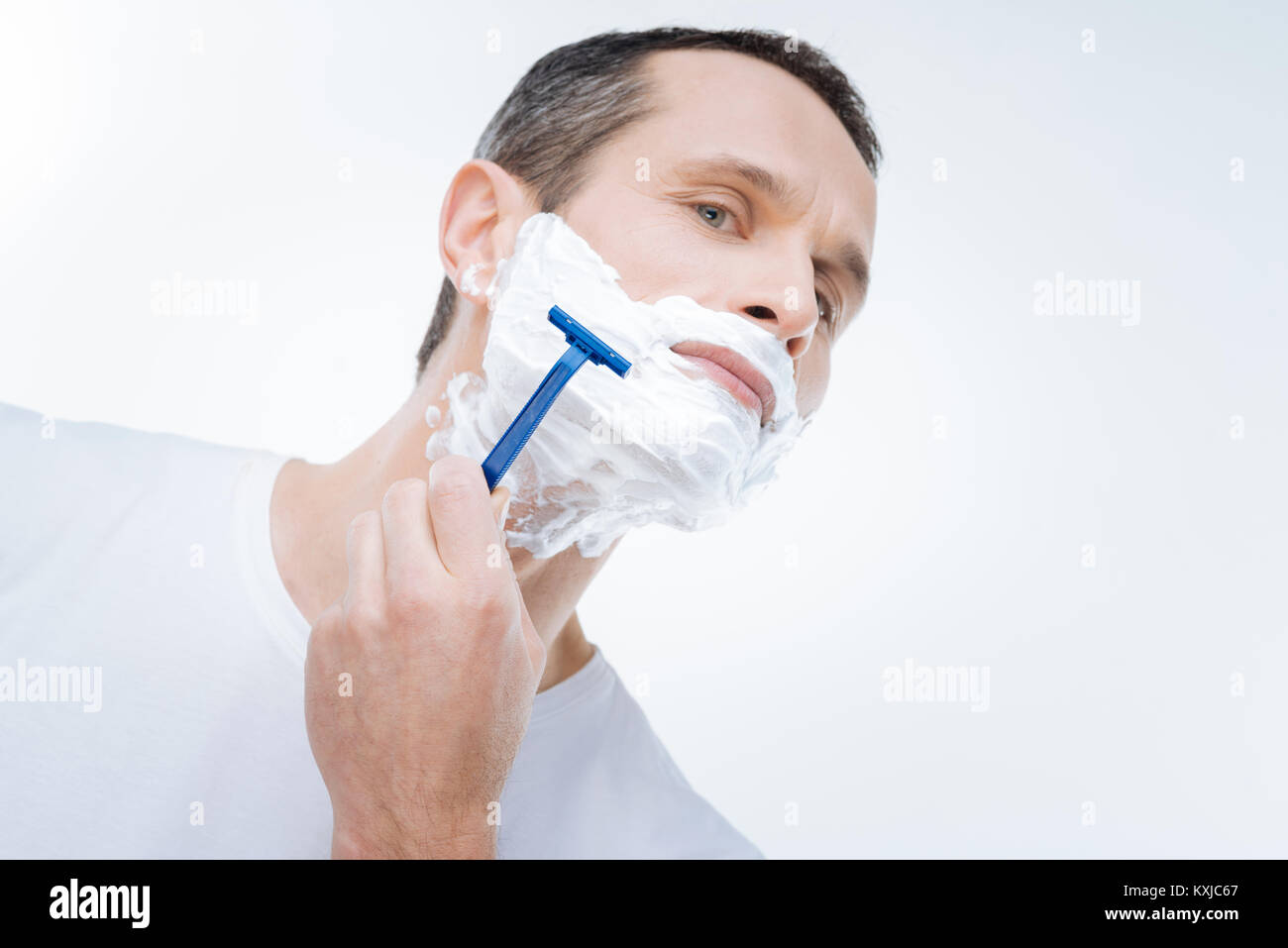 Handsome nice man holding a razor Stock Photo - Alamy