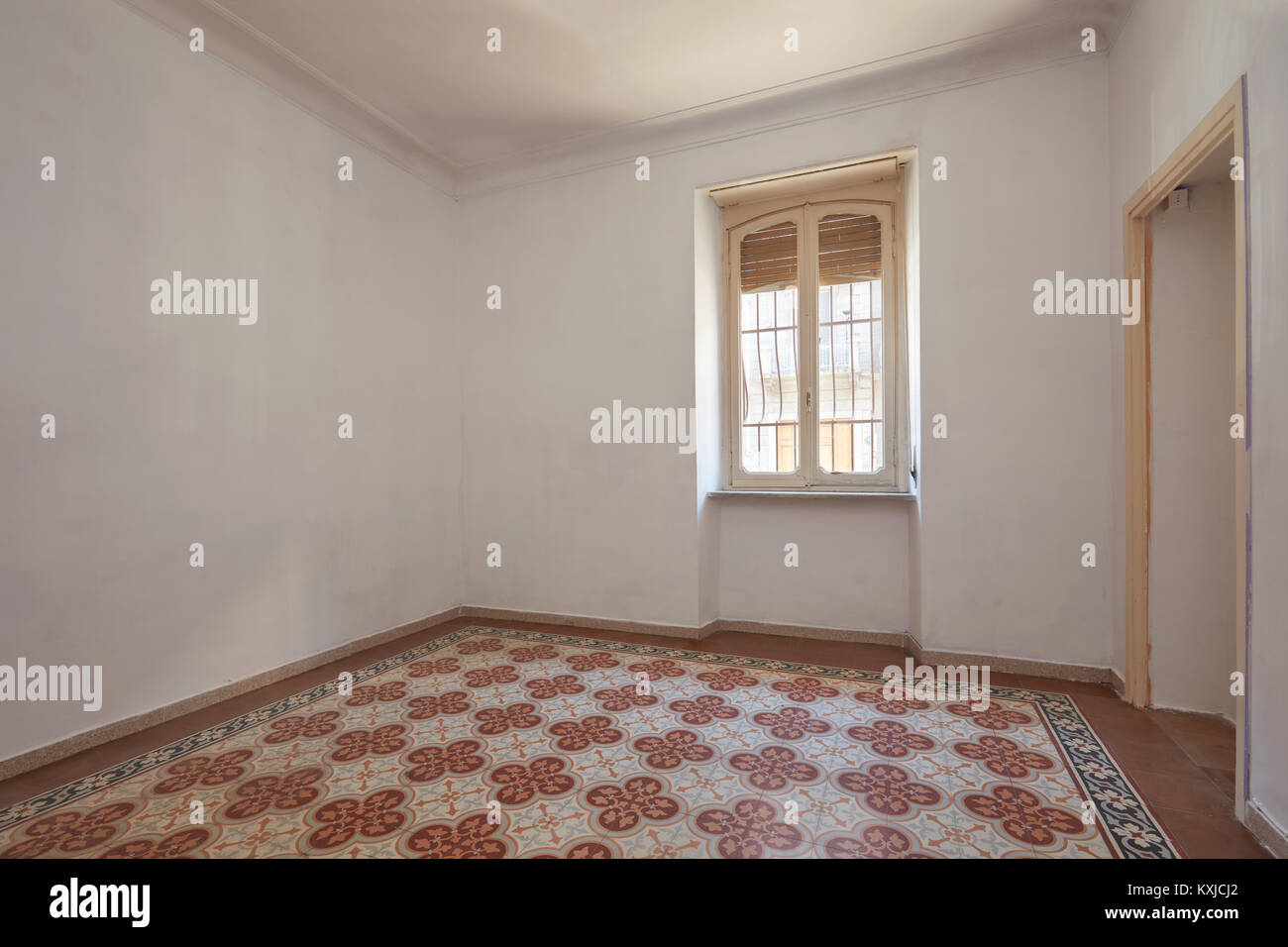 Old, empty room interior with tiled, decorated floor in a sunny day ...