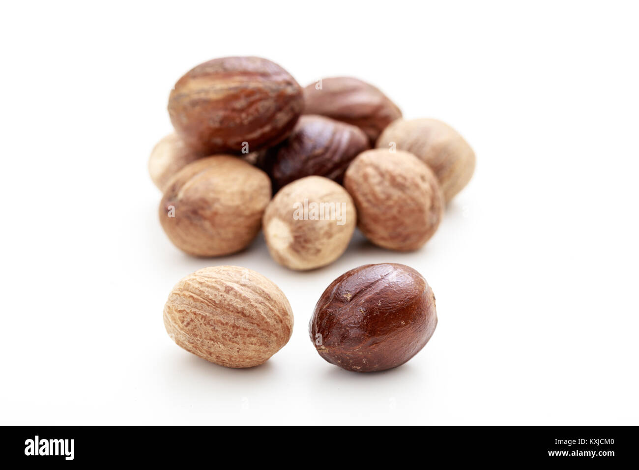 Nutmeg seeds on white background Stock Photo - Alamy