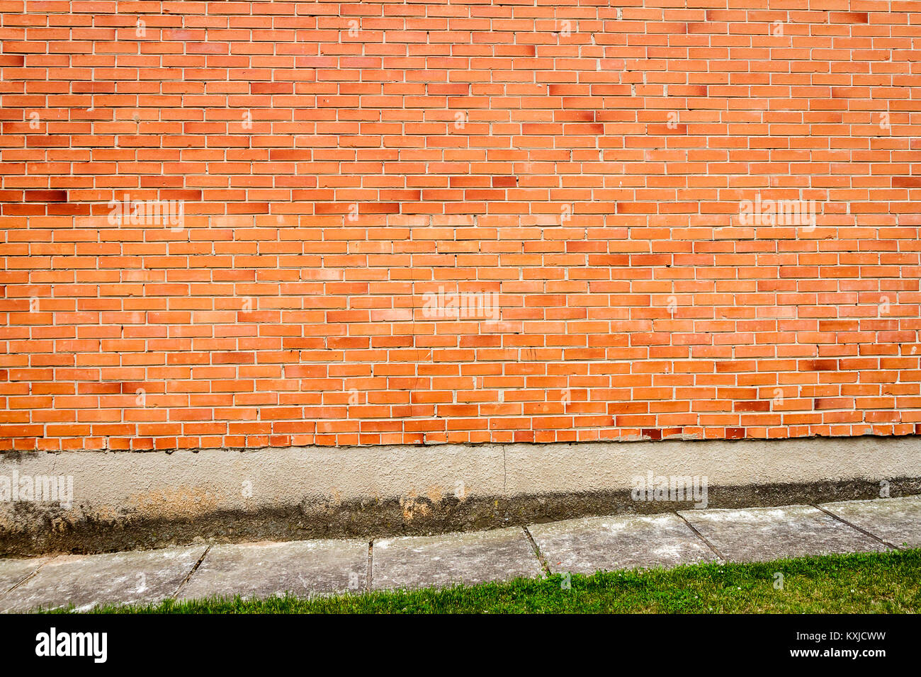 Red brick wall background with green grass Stock Photo - Alamy