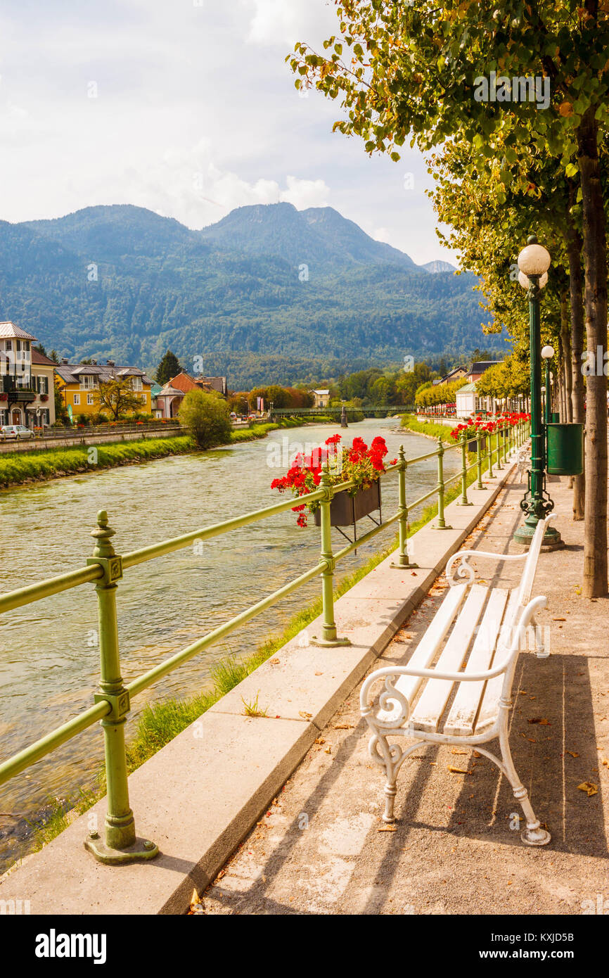 Vacant white bench on riverside esplanade facing river Traun and ...