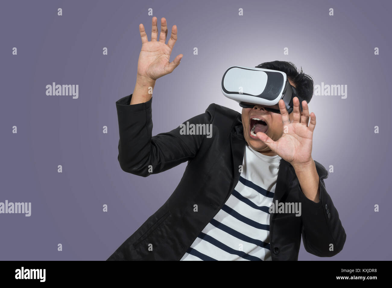 Asian Man wearing virtual reality in scared action on blue background ...