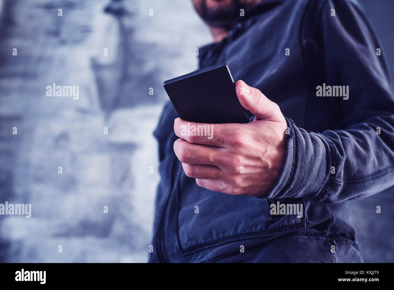 Low angle view of casual adult man reading private SMS text message on ...