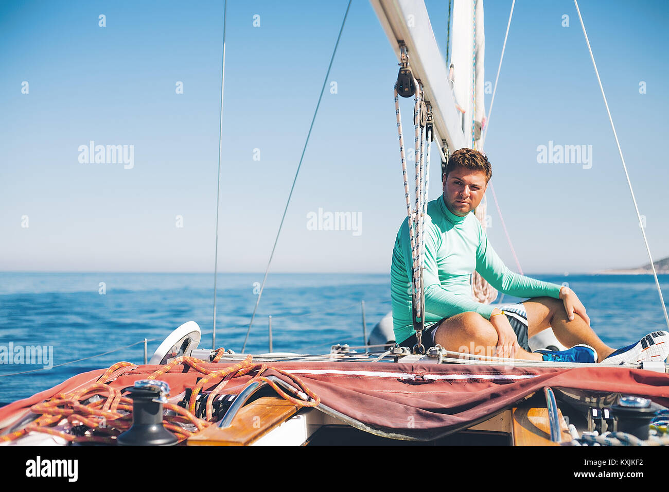 Man on sail boat Stock Photo - Alamy
