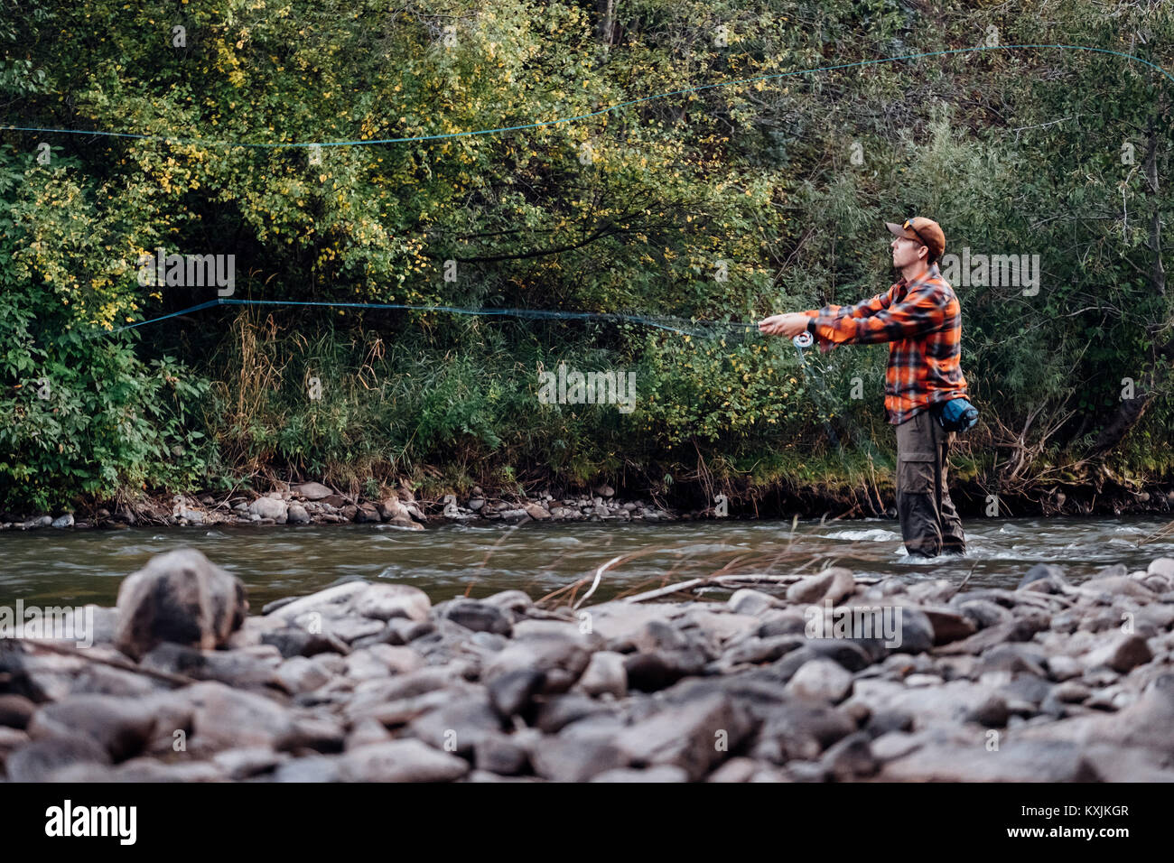 Man wading in river, fishing Stock Photo - Alamy