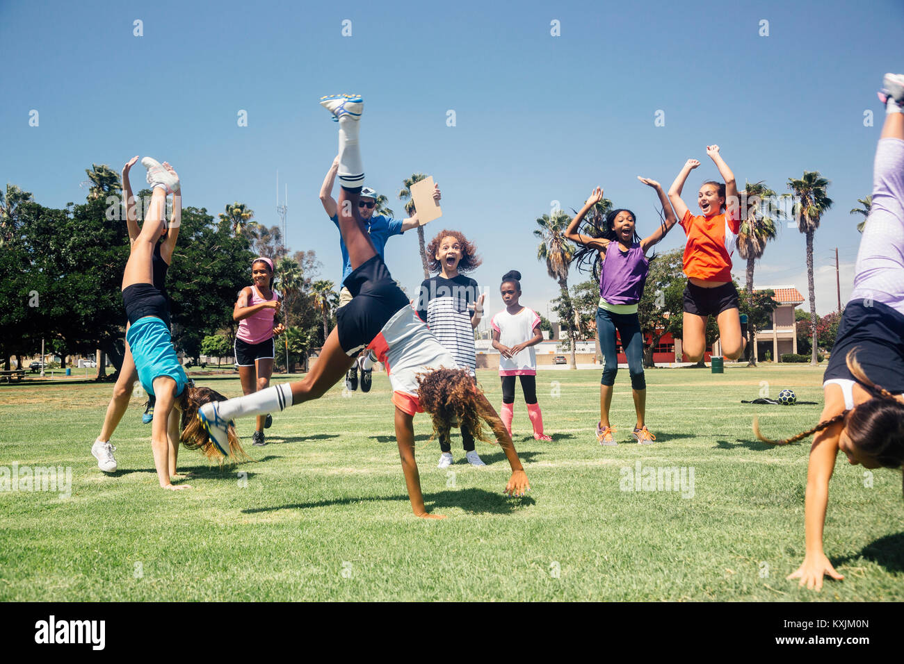 Schoolgirl soccer team doing cartwheel celebration on school sports ...