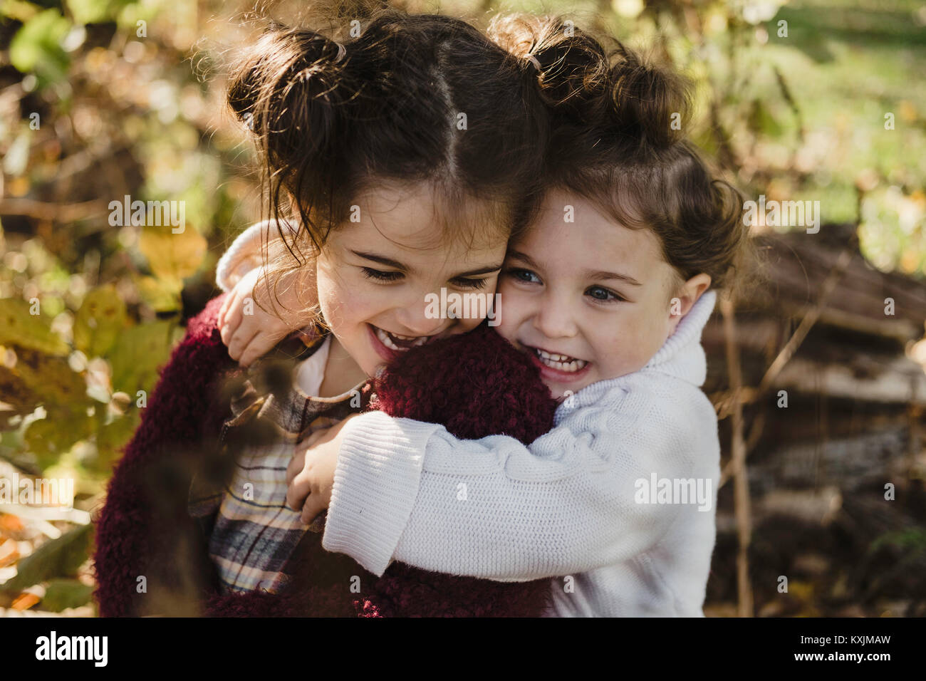 Two young sisters hugging, in rural setting Stock Photo - Alamy