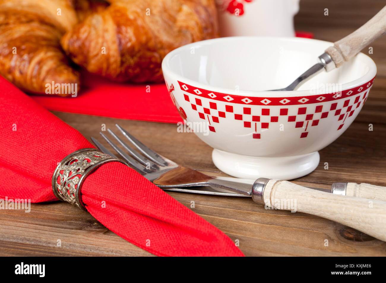 Empty cereal bowl and a matching napkin on a wooden breakfast table ...
