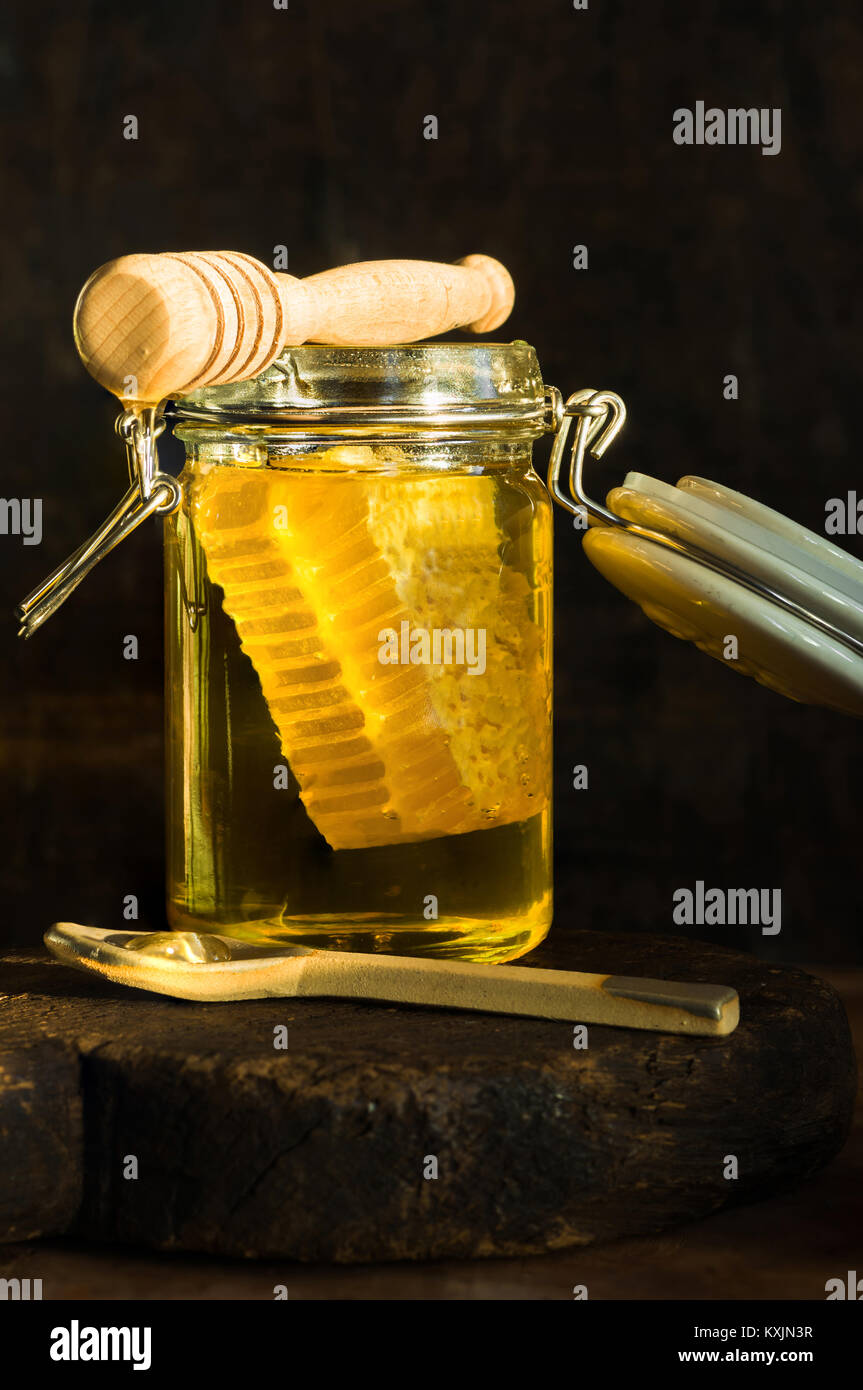 Honey in a jar with honey comb inside Stock Photo - Alamy