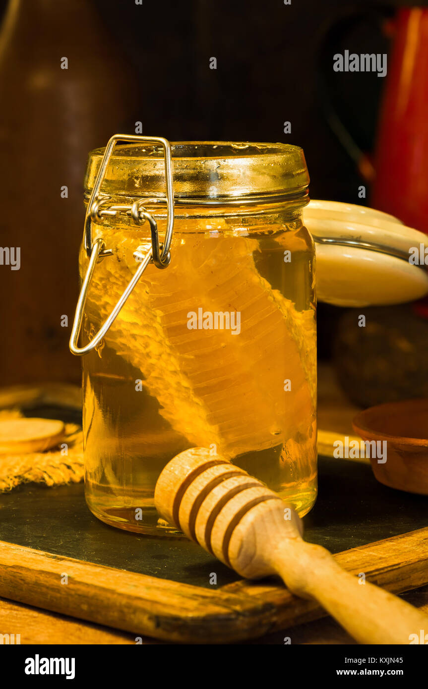 Honey in a jar with honey comb inside Stock Photo - Alamy