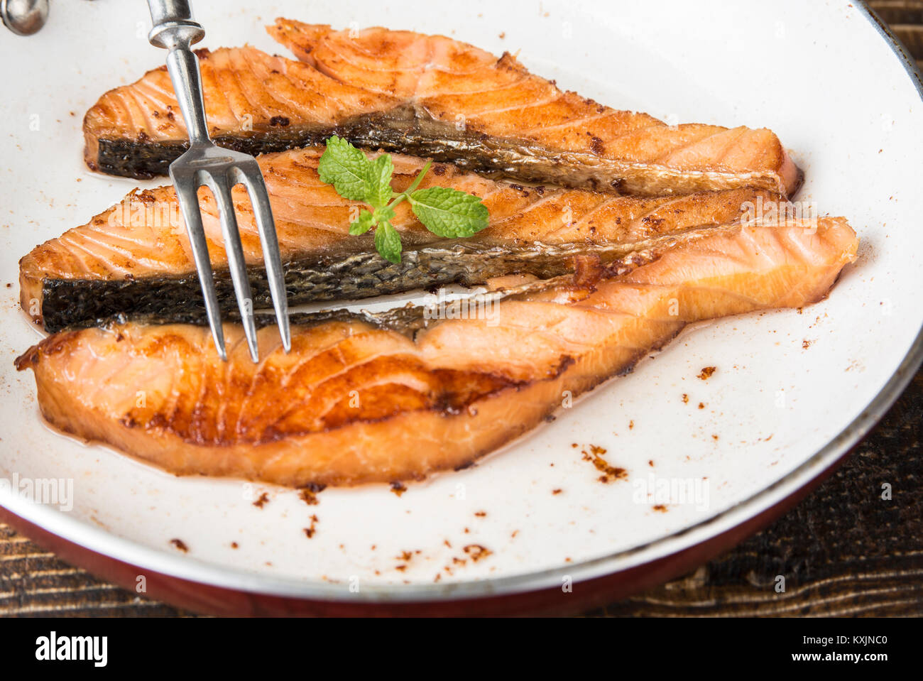 Fried salmon fillets on the pan on the wood Stock Photo - Alamy