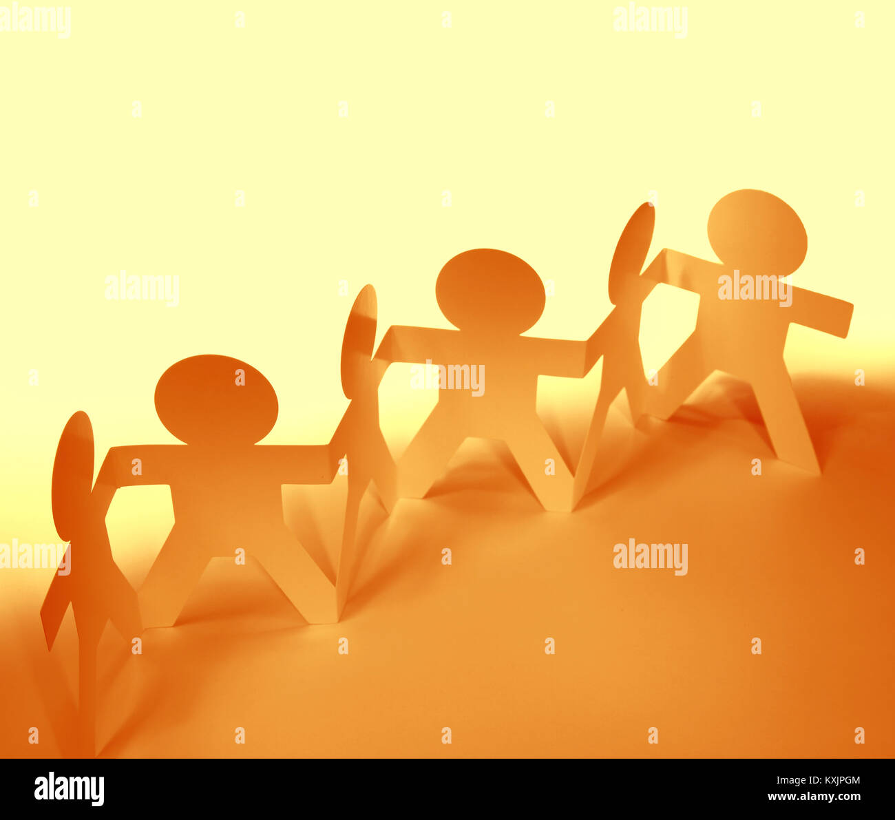 Team of paper chain people in a row holding hands Stock Photo - Alamy