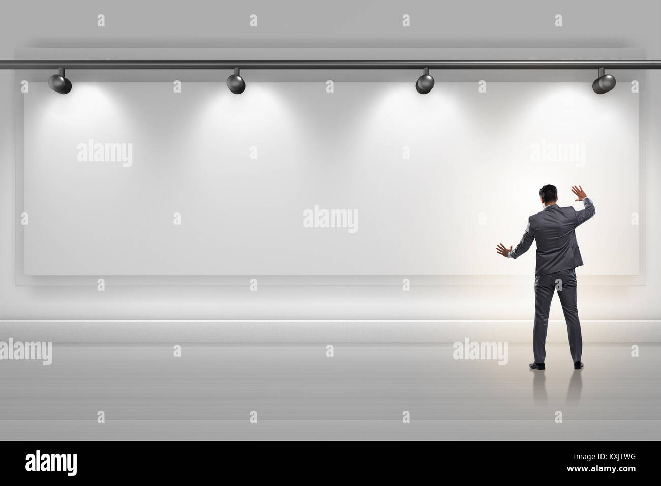 Businessman pressing virtual button on the wall lit with spotlights ...
