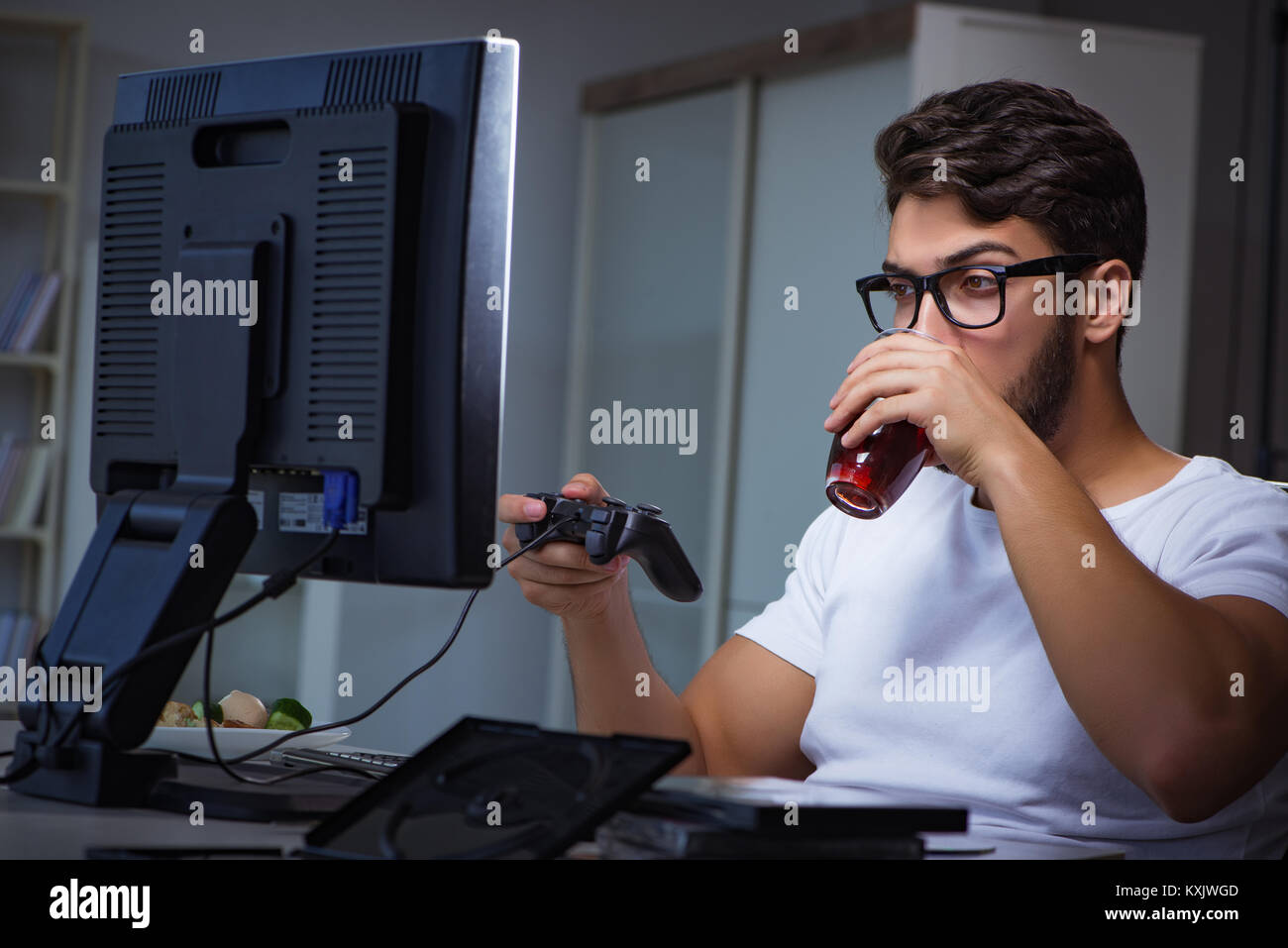 Young man playing games long hours late in the office Stock Photo - Alamy