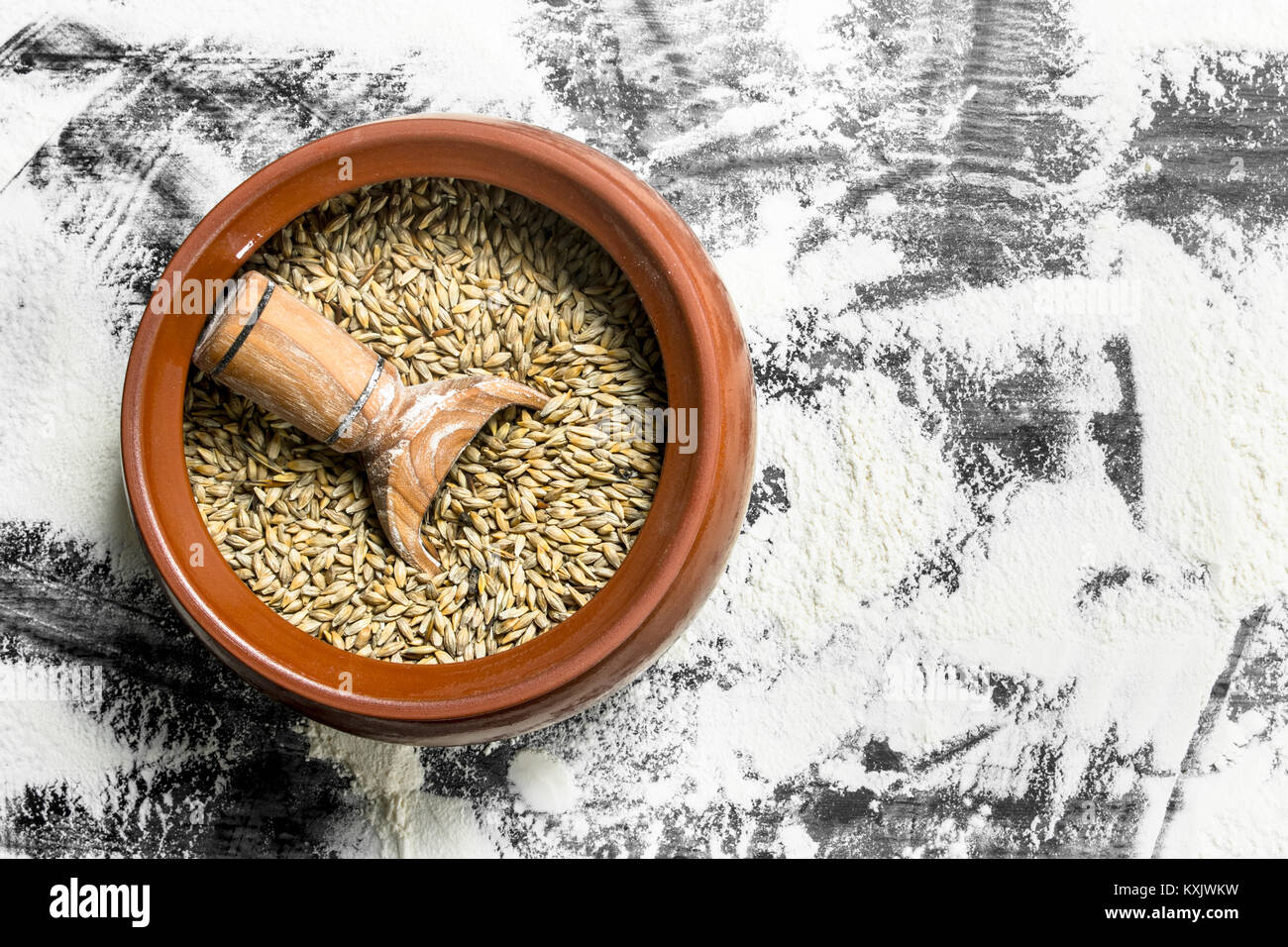 Wheat grains with a scoop in a bowl. On the stone table Stock Photo - Alamy