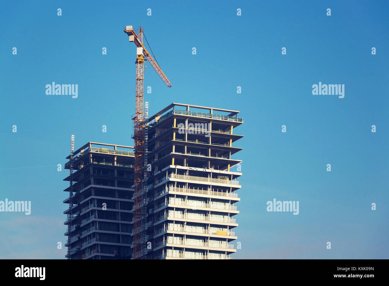 Crane on skyscraper construction site with windows reflecting sky Stock ...