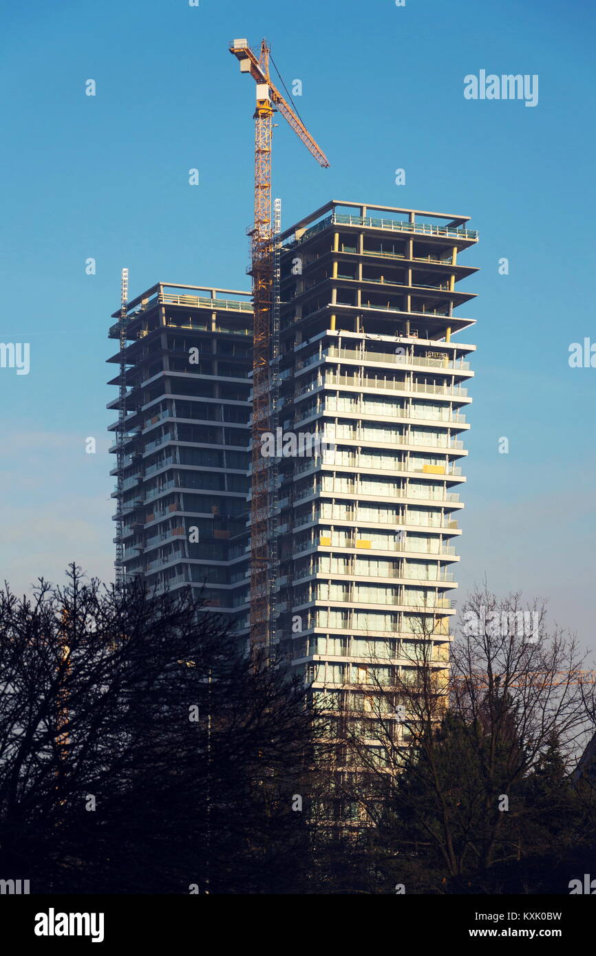 Crane on skyscraper construction site with windows reflecting sky Stock ...