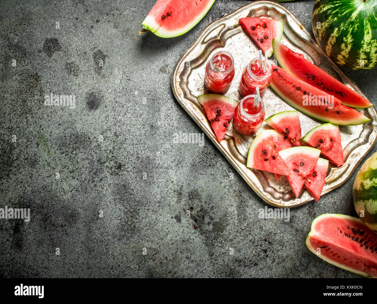 Watermelon juice in bottles on a steel tray. On a rustic background ...