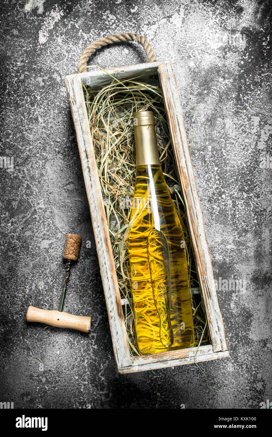 Wine background. A bottle of white wine in an old box. On a rustic ...