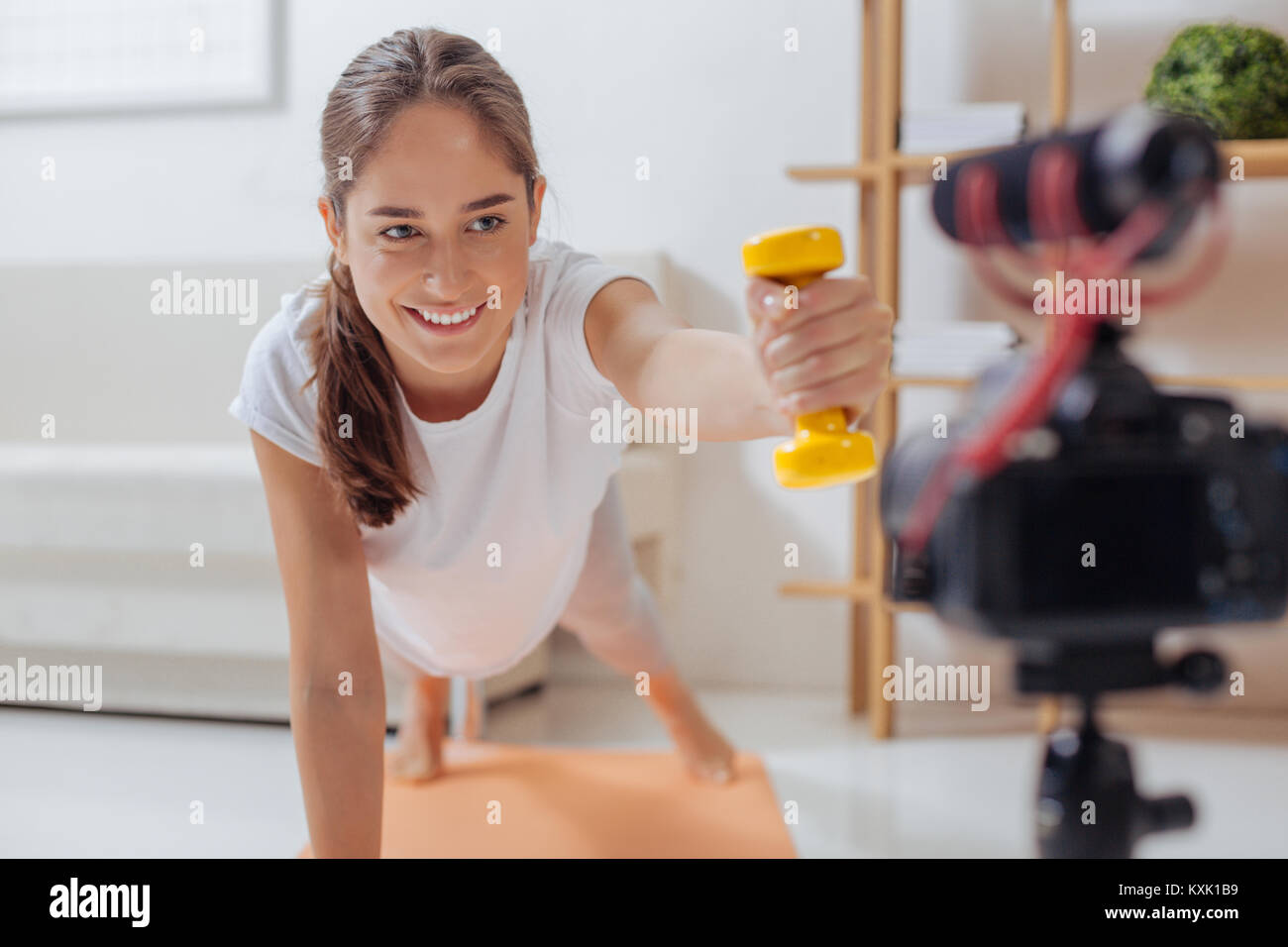 Happy blogger holding a hand weight while smiling to the camera Stock ...