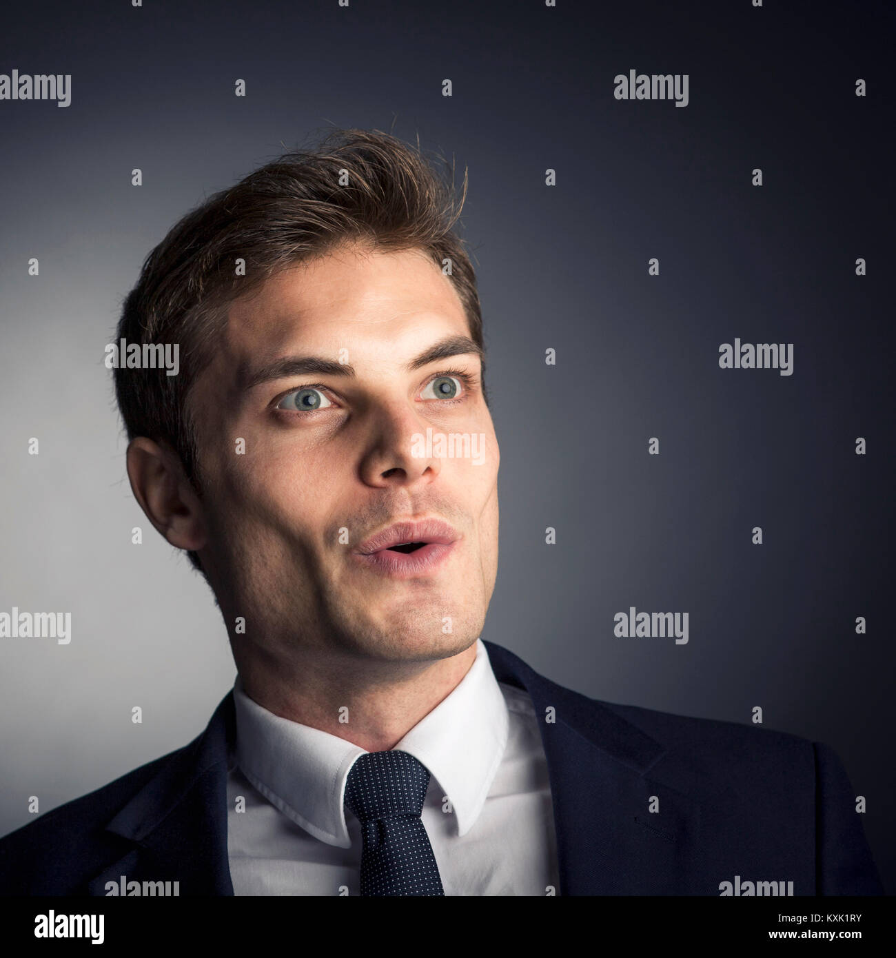 portrait of surprised businessman on gray background Stock Photo - Alamy