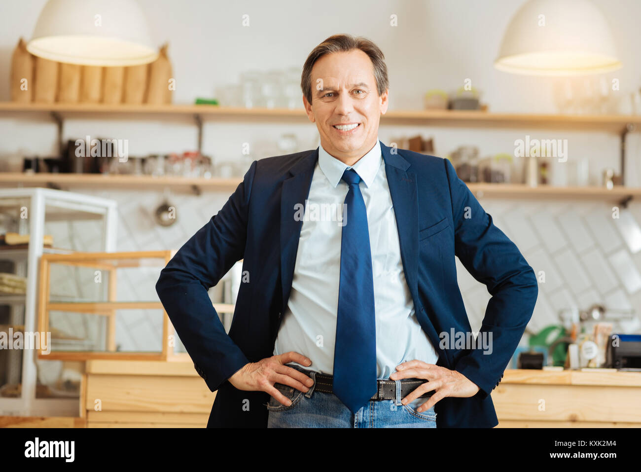 Busy joyful man standing in the shop and smiling Stock Photo - Alamy